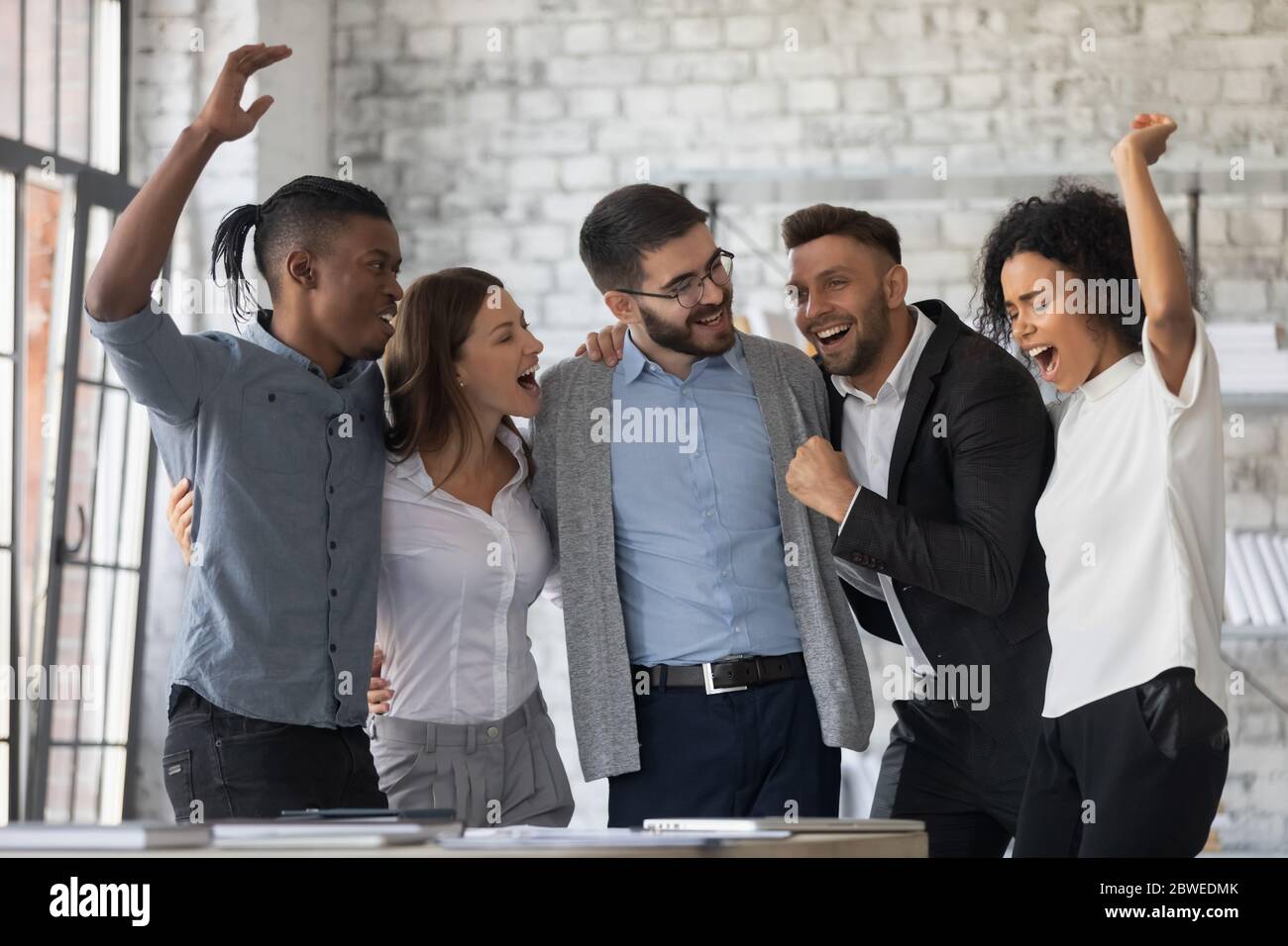Excited diverse colleagues celebrating teamwork success, business achievement Stock Photo - Alamy