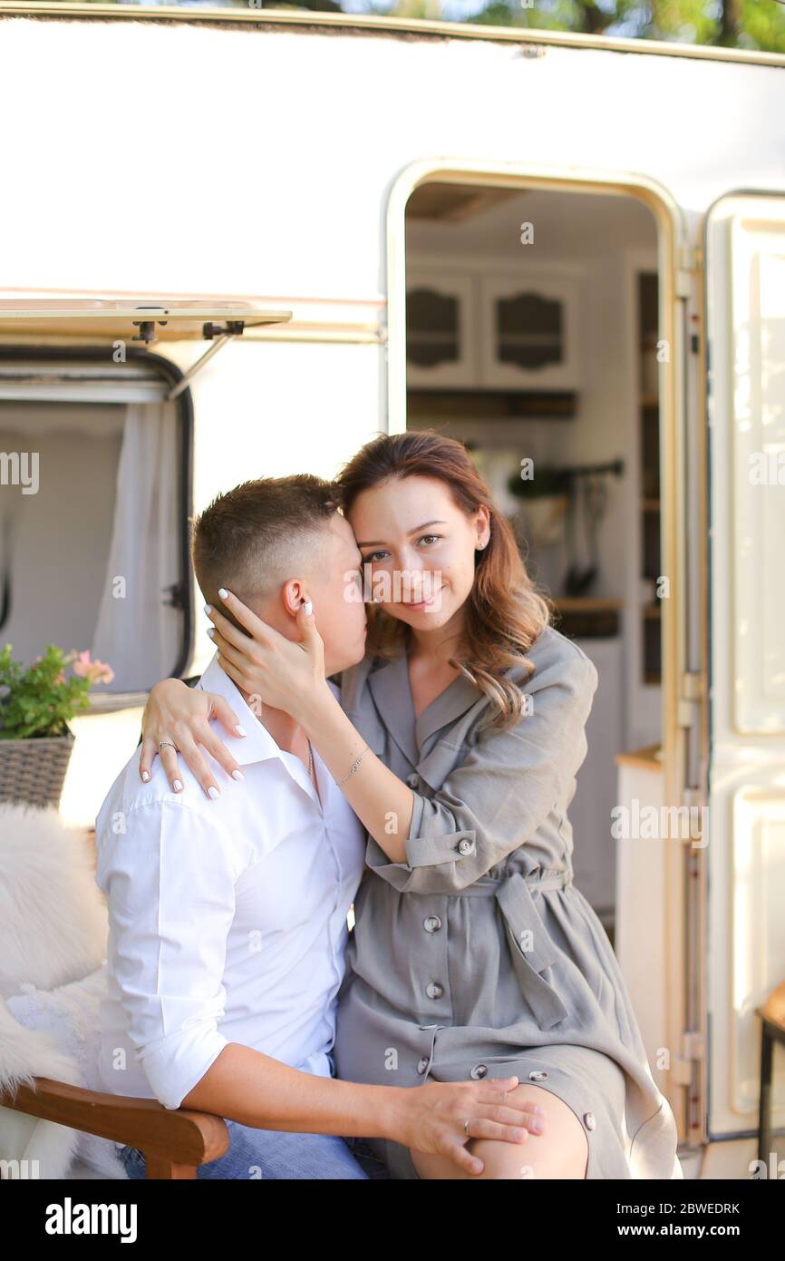 Portrait of young nice wife hugging husband near house on wheels Stock ...