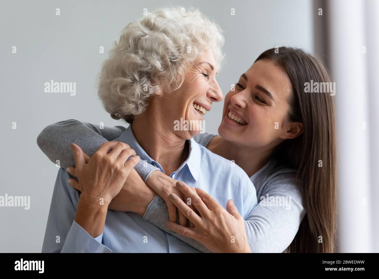 Loving cheerful grownup daughter hugs elderly mother laughing having fun Stock Photo - Alamy