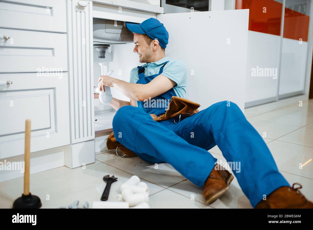 Handsome smiling plumber at the kitchen hi-res stock photography and ...