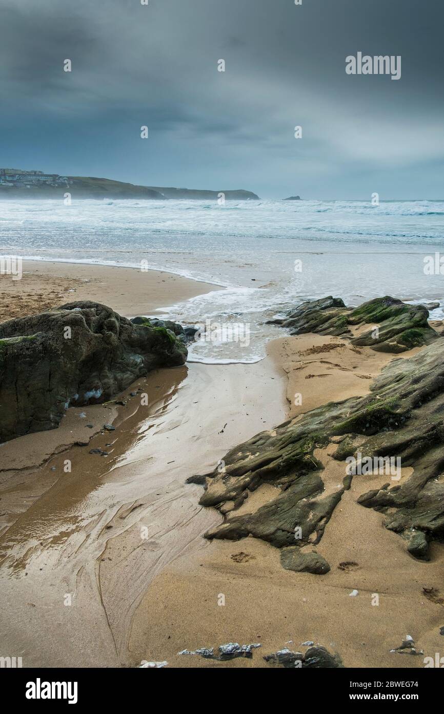 Incoming tide swirling around rocks at Fistral in Newquay in Cornwall ...