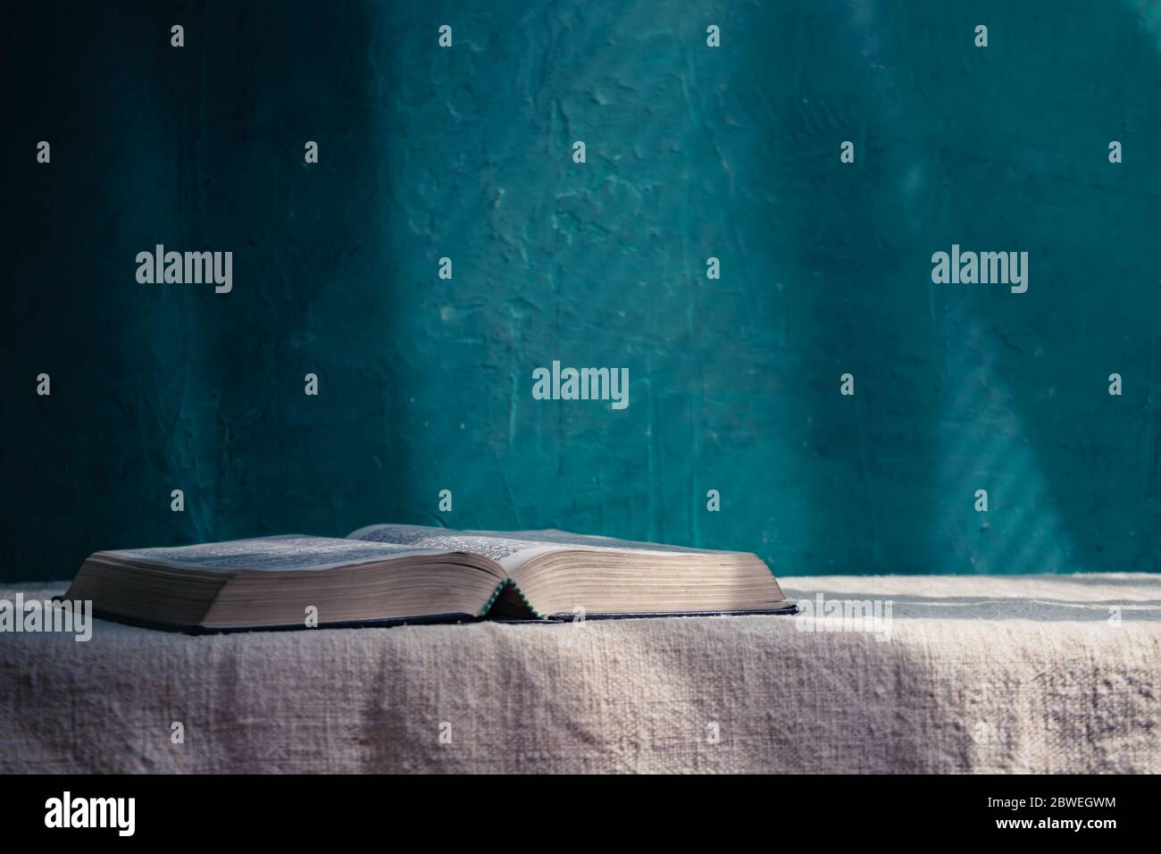 Open Holy Bible on a old table. Beautiful green wall background Stock ...
