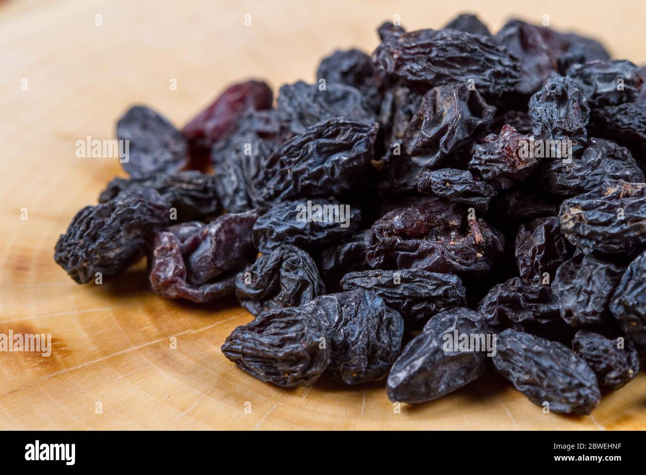 Uzbek blue raisins closeup on a wooden table. Baking ingredients ...