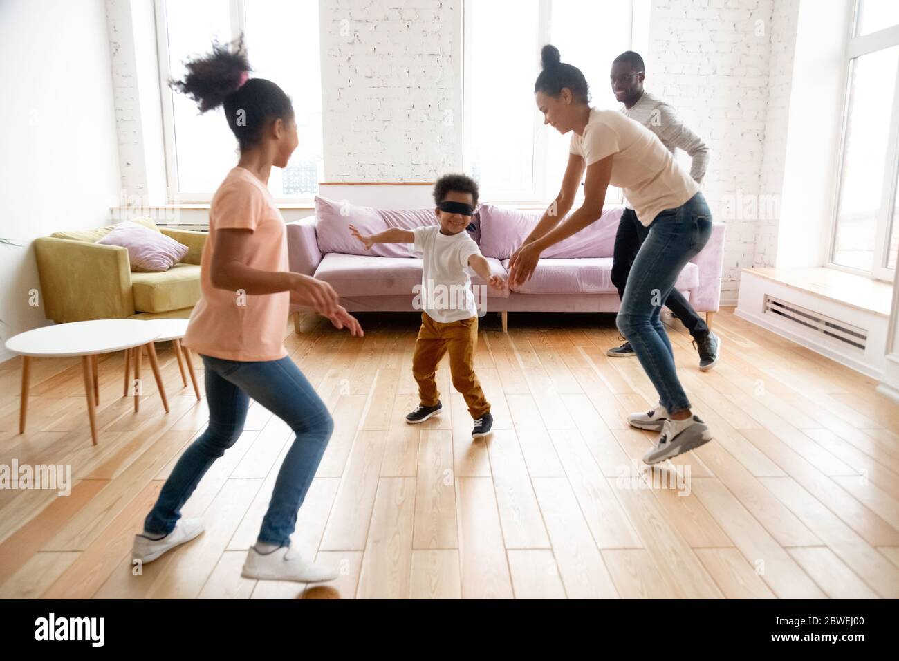 In living room African family play hide-and-seek game Stock Photo - Alamy