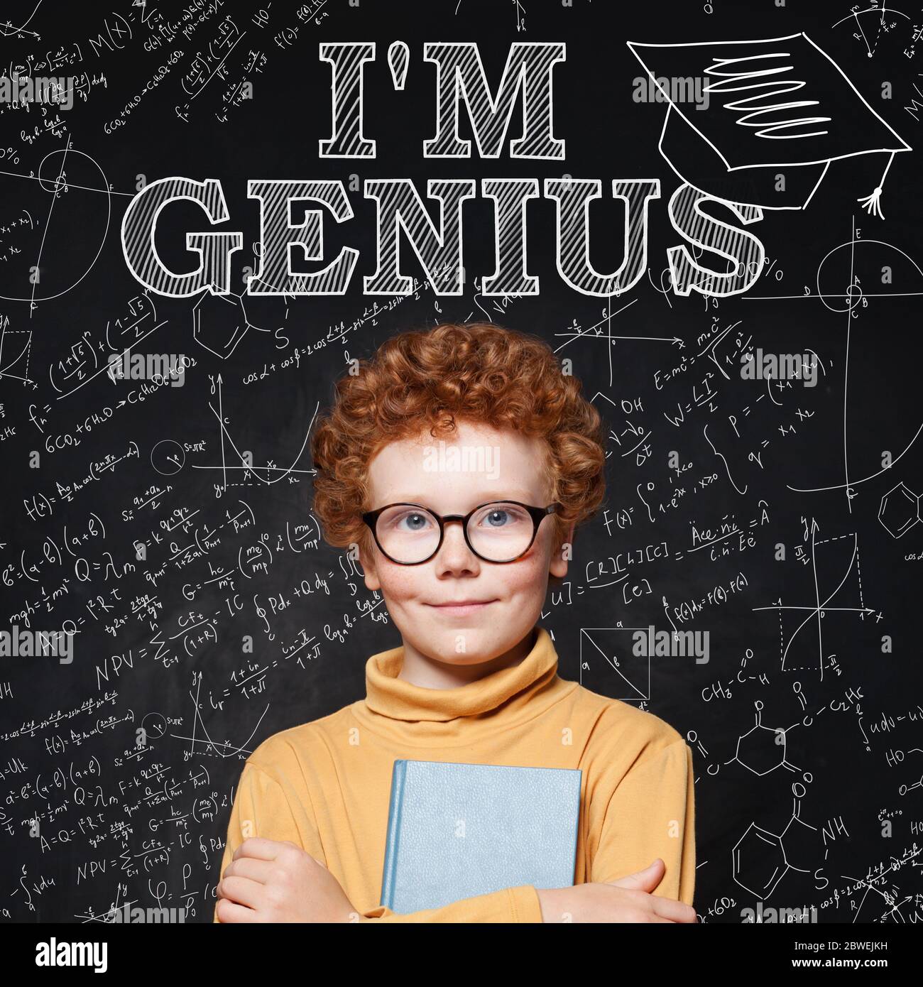 Clever little boy with ginger hair wearing glasses in classroom against ...