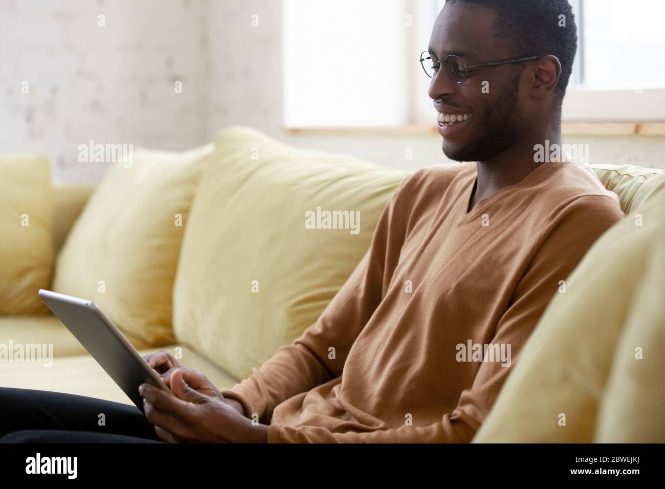 African guy holding digital tablet laugh enjoy funny videos Stock Photo ...