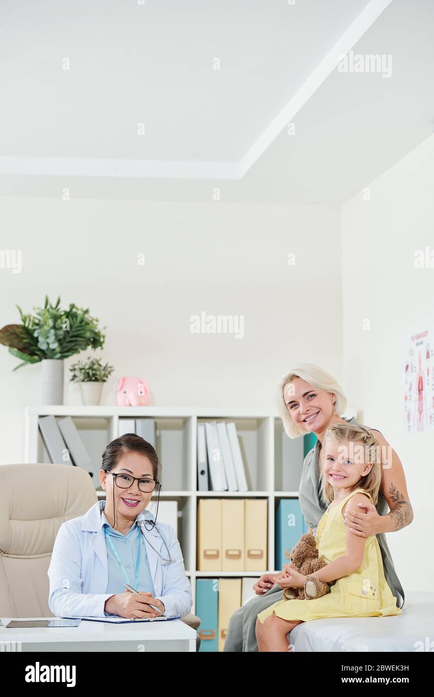 Happy mother and daughter in office of pediatrician after annual check ...