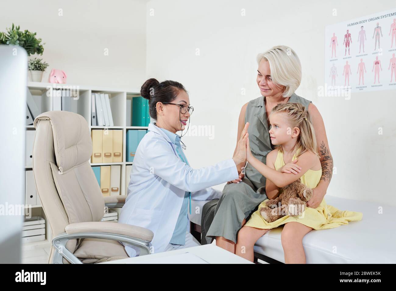 Pediatrician giving his little patient high five after annual check-up ...