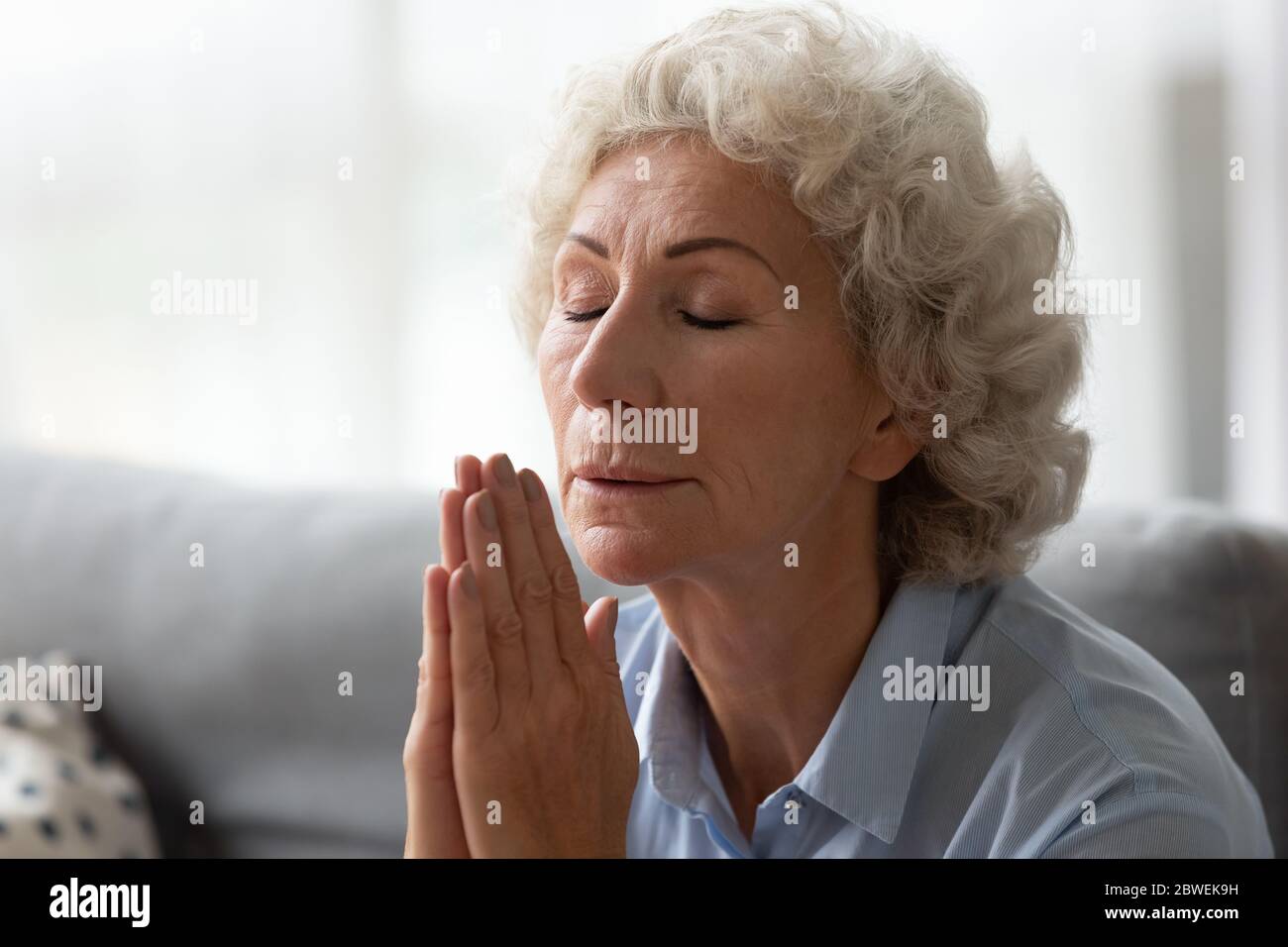 Elderly woman praying closed eyes folded palms together Stock Photo - Alamy