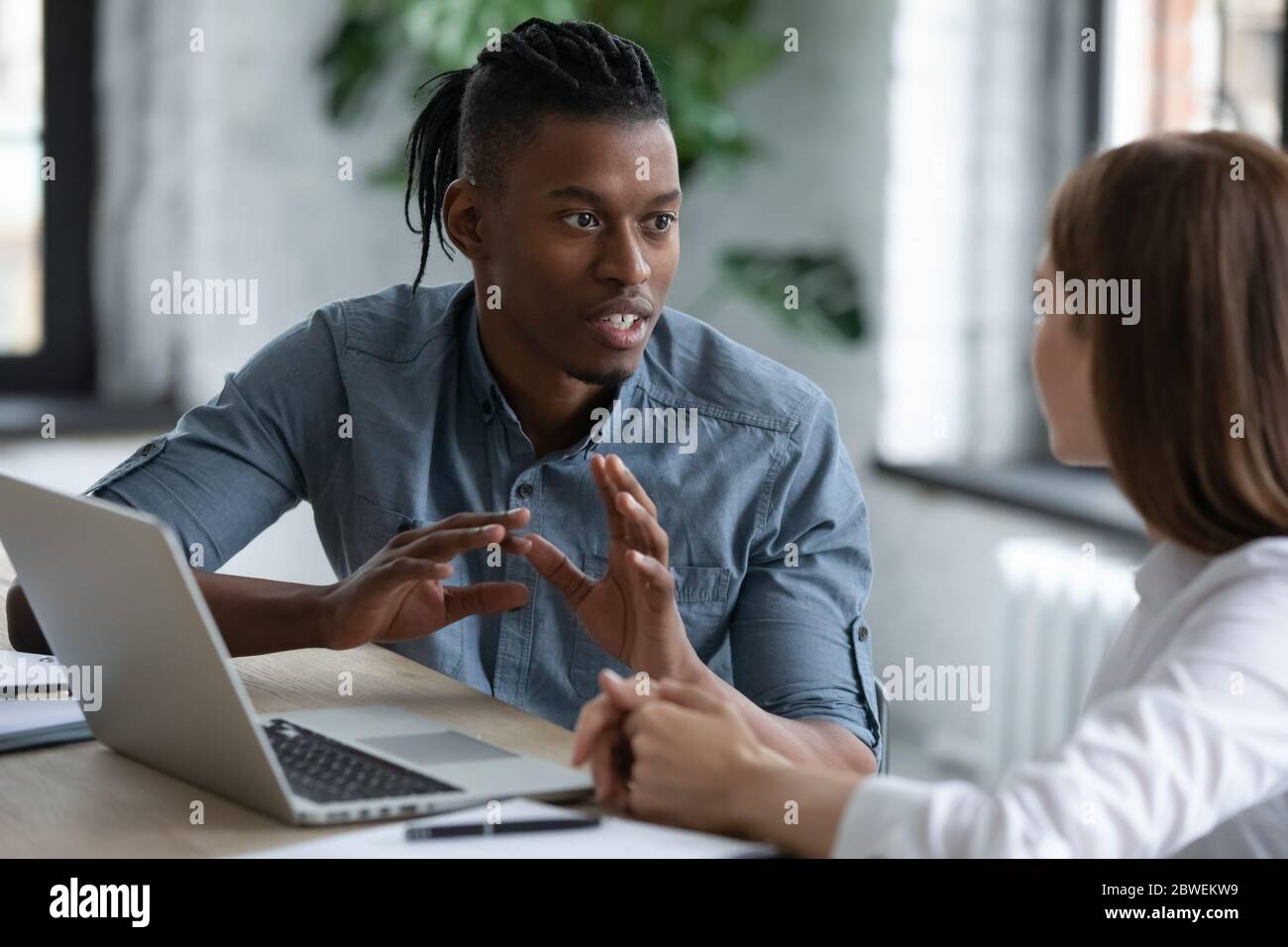 Confident African American mentor teaching new employee, giving ...