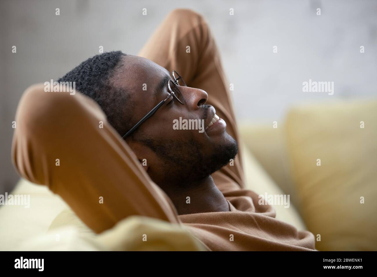 Closeup peaceful young african ethnicity man resting leaned on couch ...