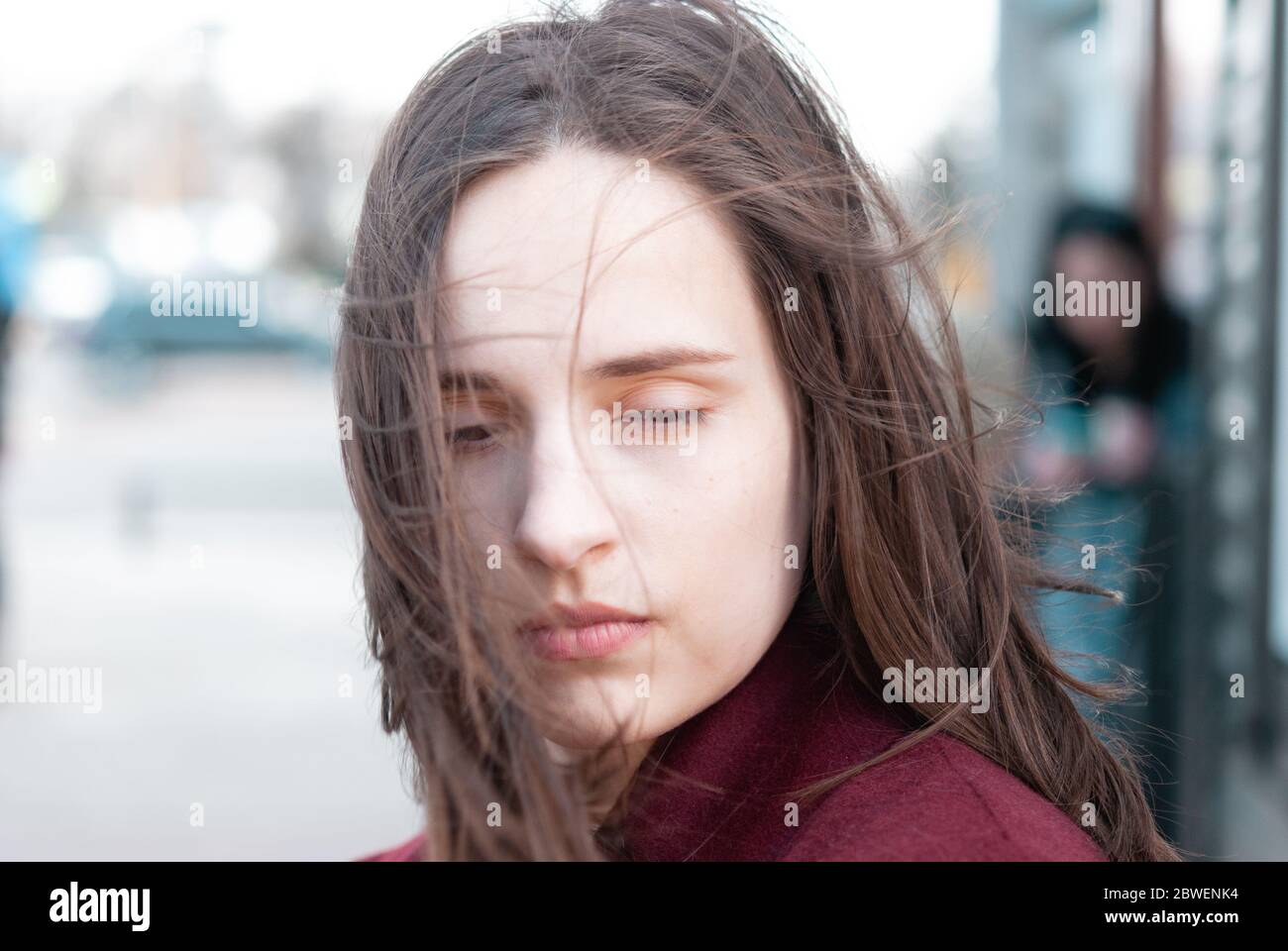 Portrait of beautiful young woman with wind fluttering hair. Closeup ...