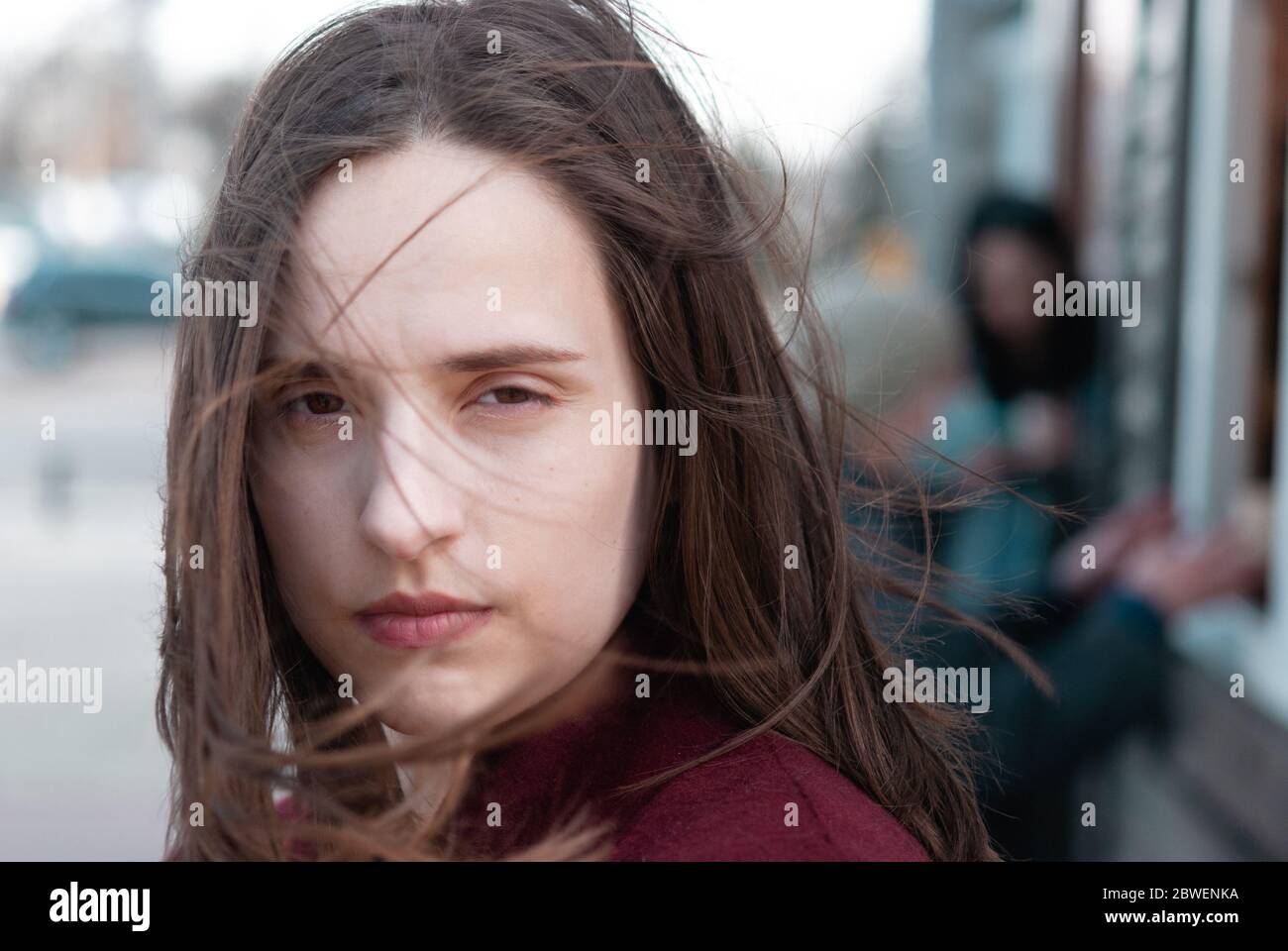 Portrait of beautiful young woman with wind fluttering hair. Closeup ...