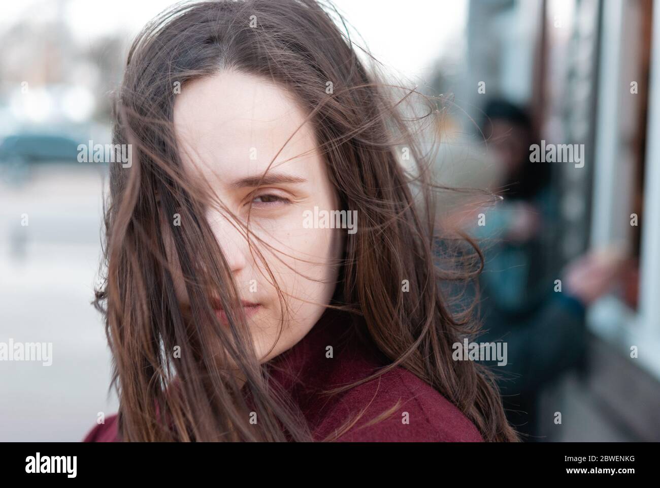Portrait of beautiful young woman with wind fluttering hair. Closeup ...