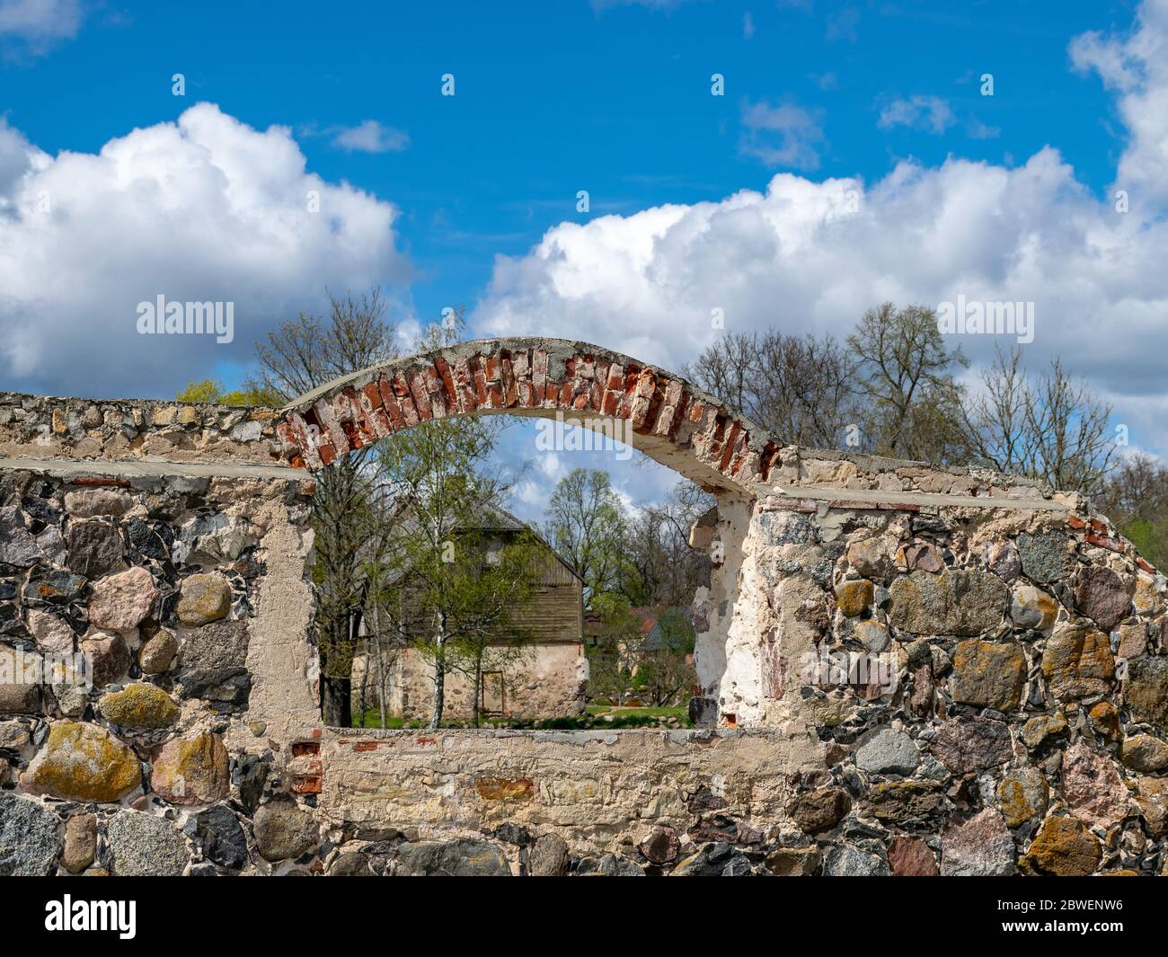 spring landscape with an old stone building wall and arched windows ...