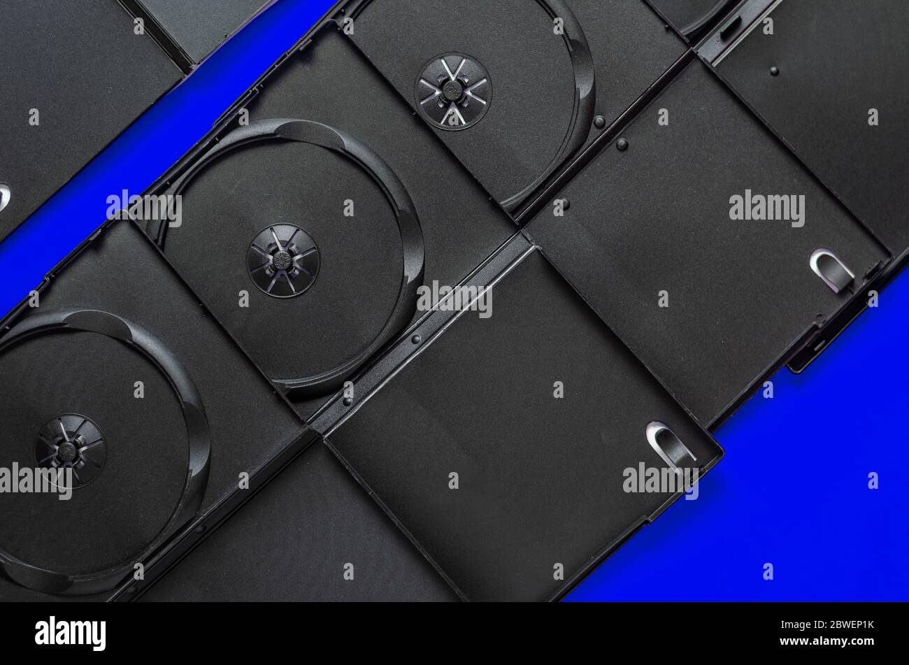 Black empty open boxes for DVD discs on a blue background. Abstract ...