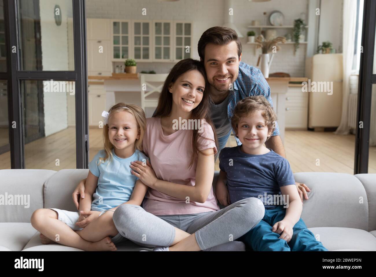 Portrait of smiling young parents hug with small kids Stock Photo - Alamy