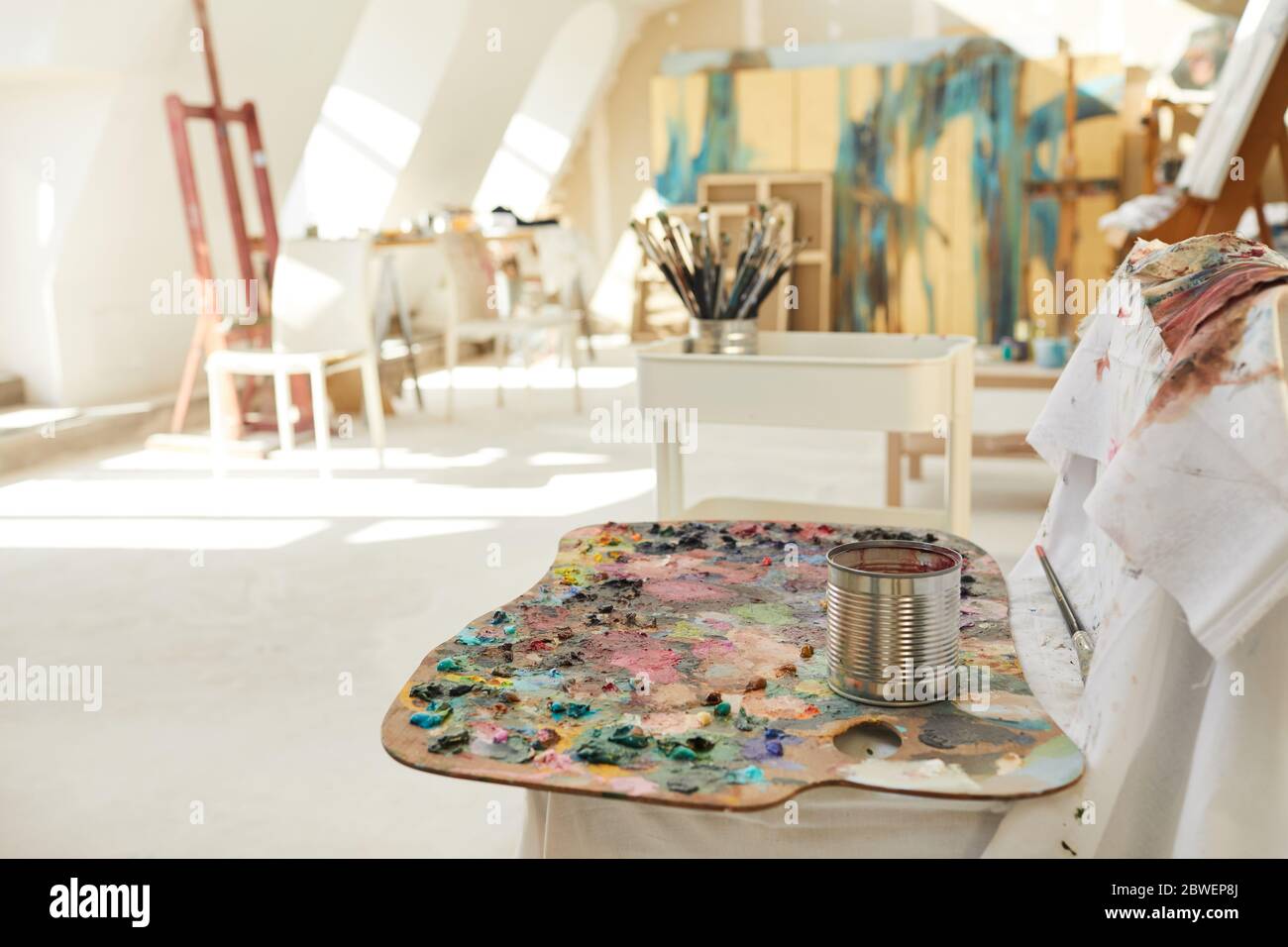 Background image of empty art studio lit by sunlight, focus on artist ...