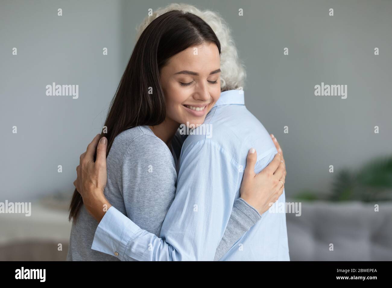 Sincere loving adult granddaughter cuddles to elderly grandmother Stock ...