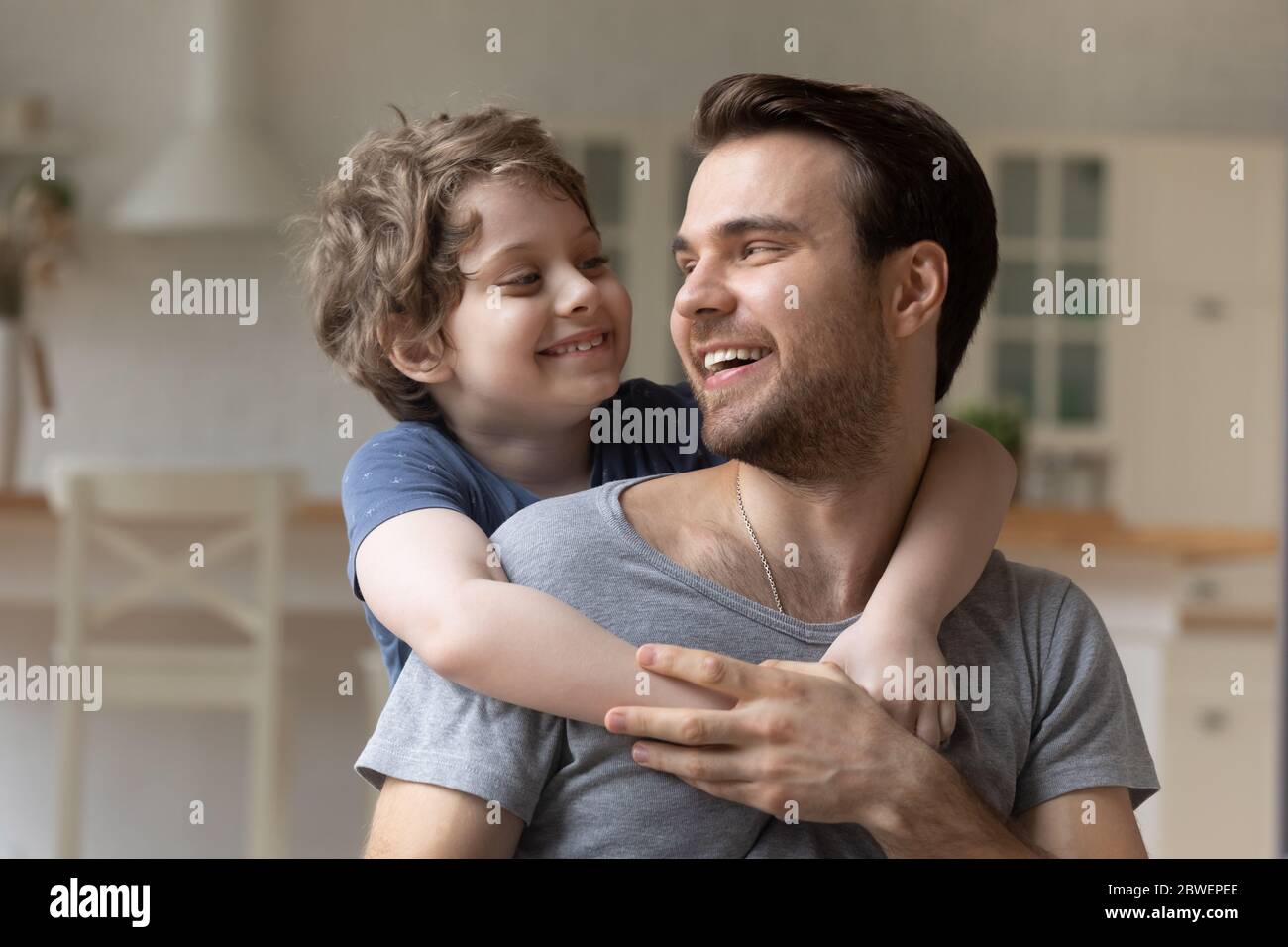 Smiling little boy hug young dad showing love Stock Photo - Alamy