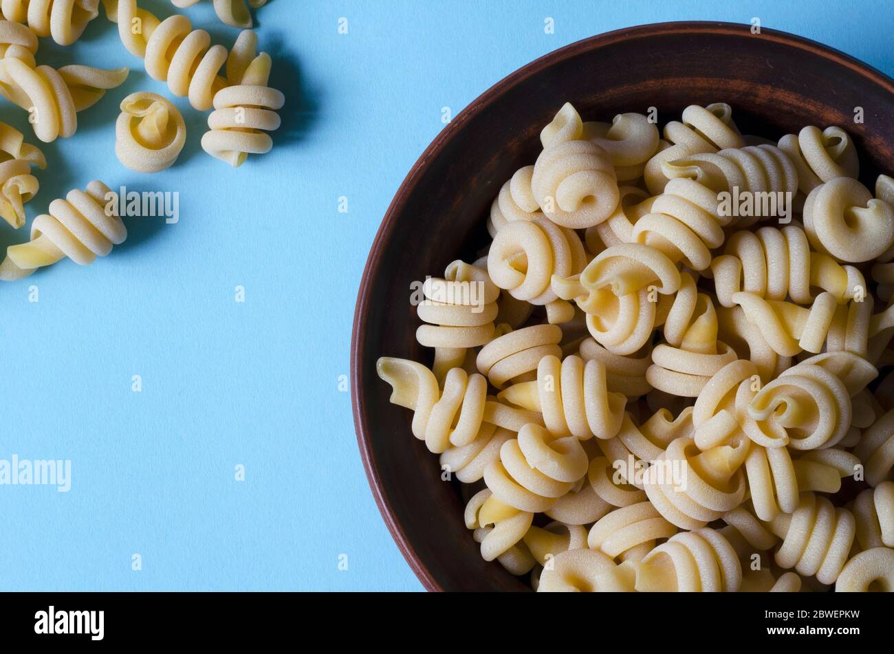 Serving Uncooked insalatonde pasta in a bowl on a light blue background ...