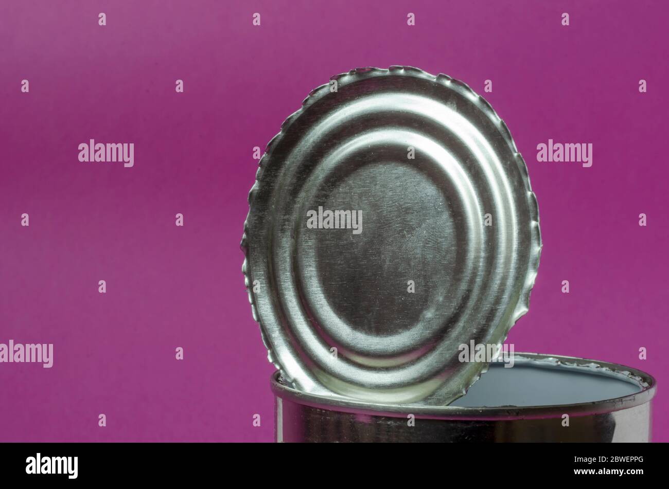 Open tin can lid close-up. Torn uneven edges of a metal cover on a ...