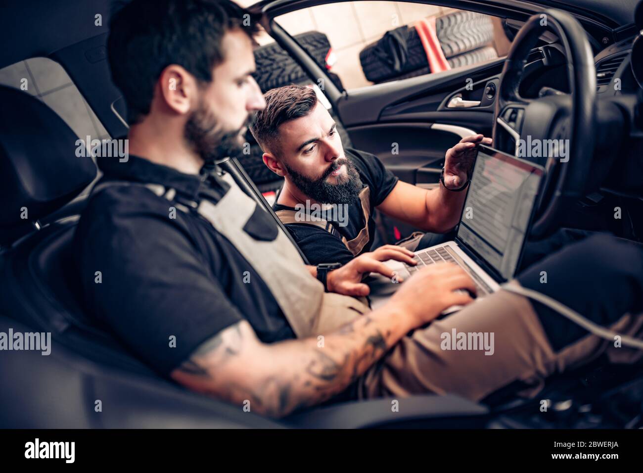 Side view.Two modern mechanics work in repair service. Concept of work ...