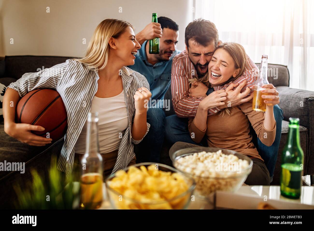 Cheerful group of friends watching basketball on tv.Young fans watching ...