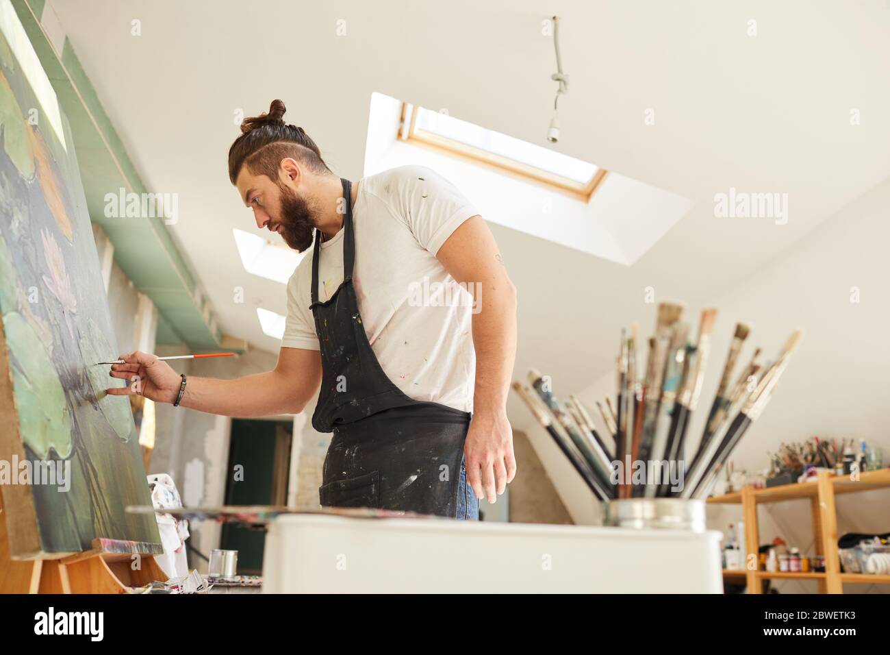 Side view portrait of contemporary bearded artist painting picture on ...