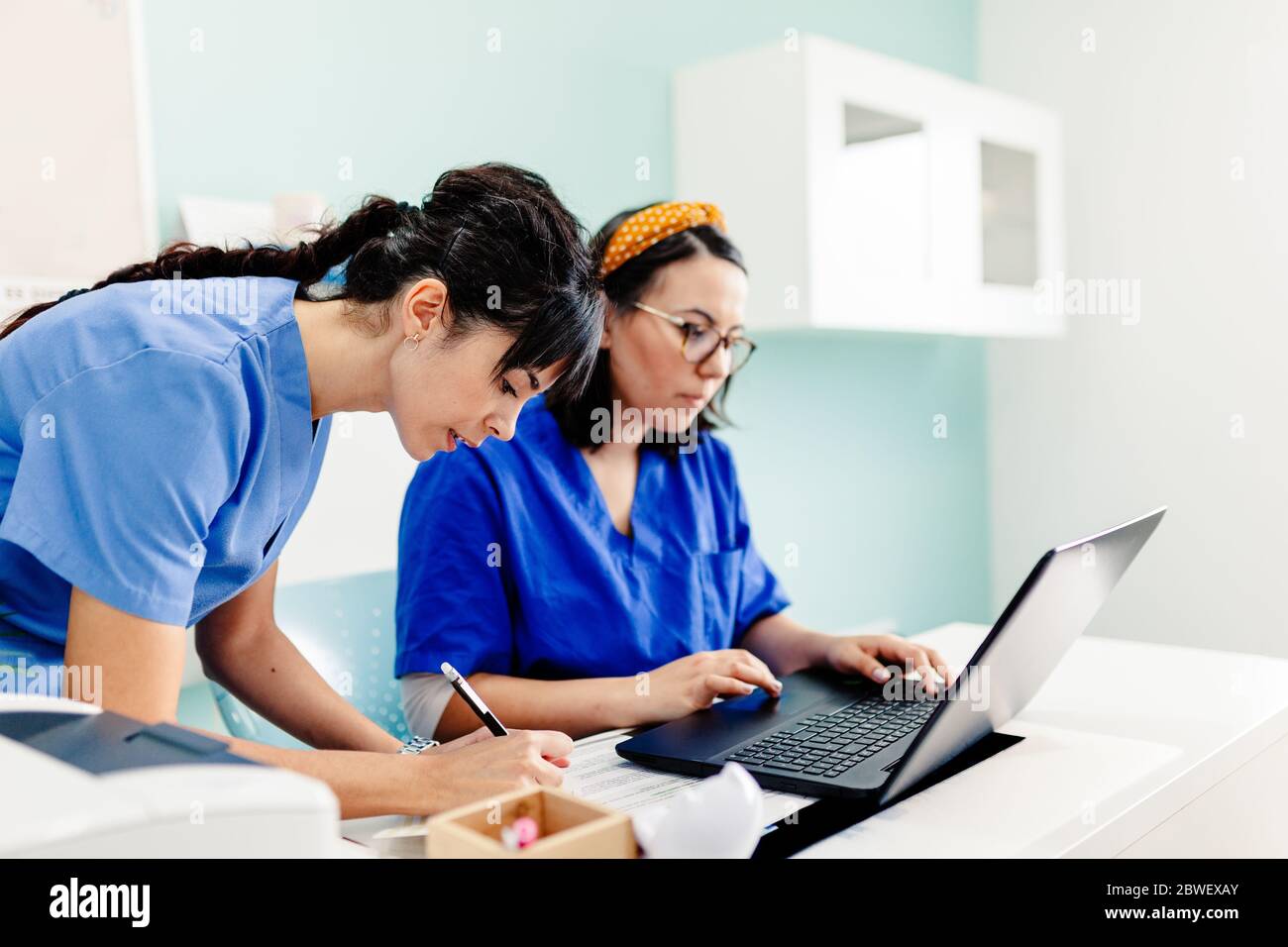 Female doctor and nurse using the laptop in the clinic Stock Photo - Alamy