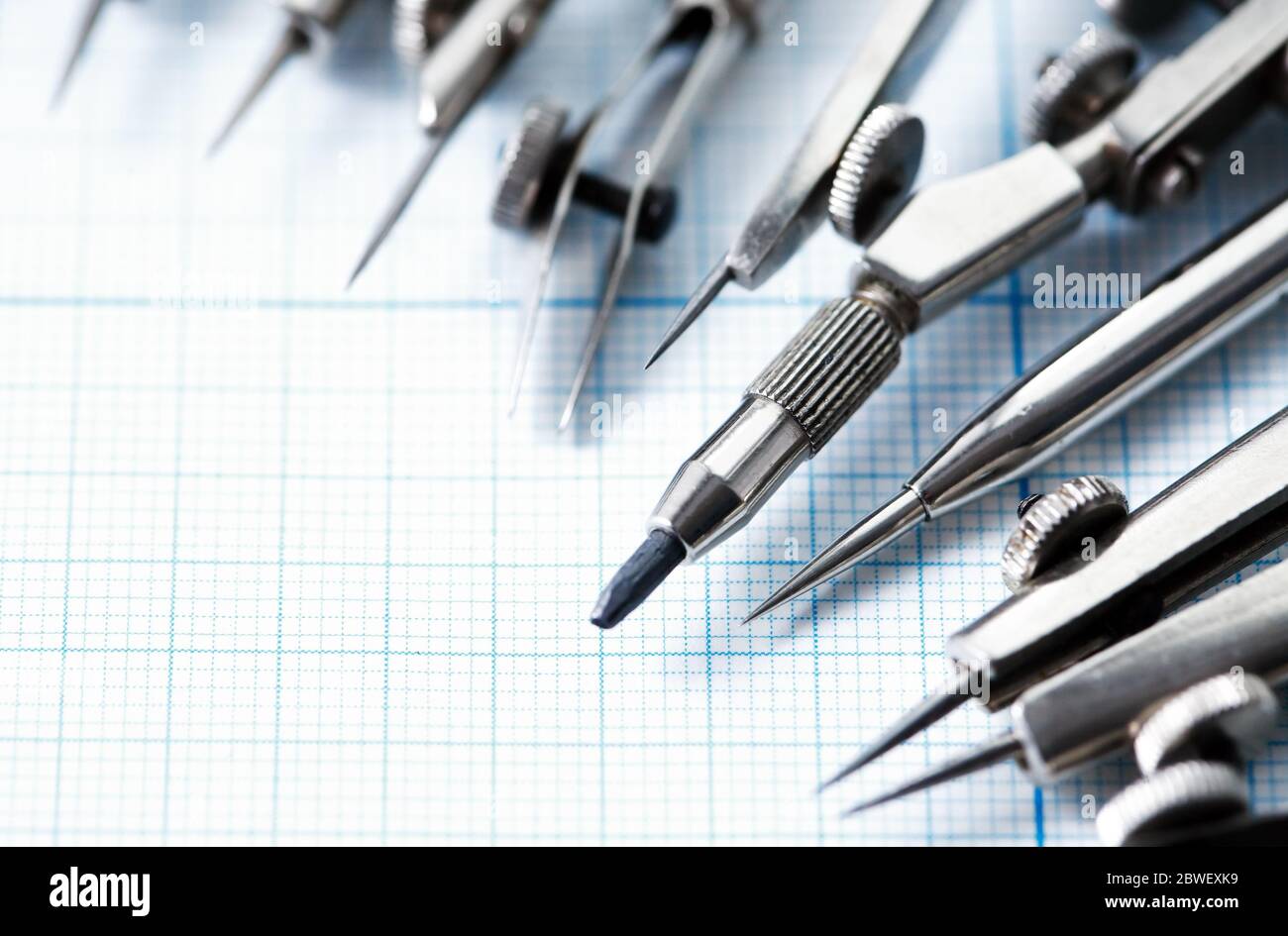 Set of old drawing tools on background with graph paper Stock Photo - Alamy