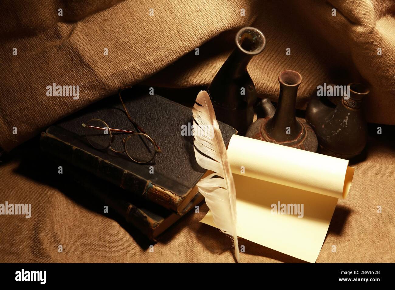 Vintage still life with old books and quill pen on canvas background ...