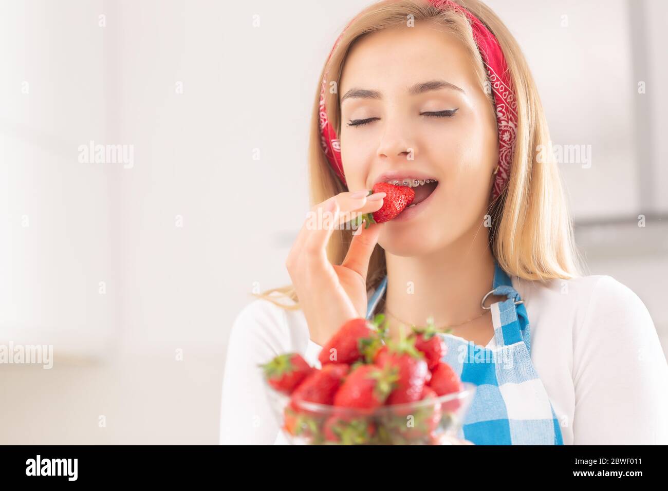 Beuatiful young woman enjoying the taste of a bite from a fresh ...