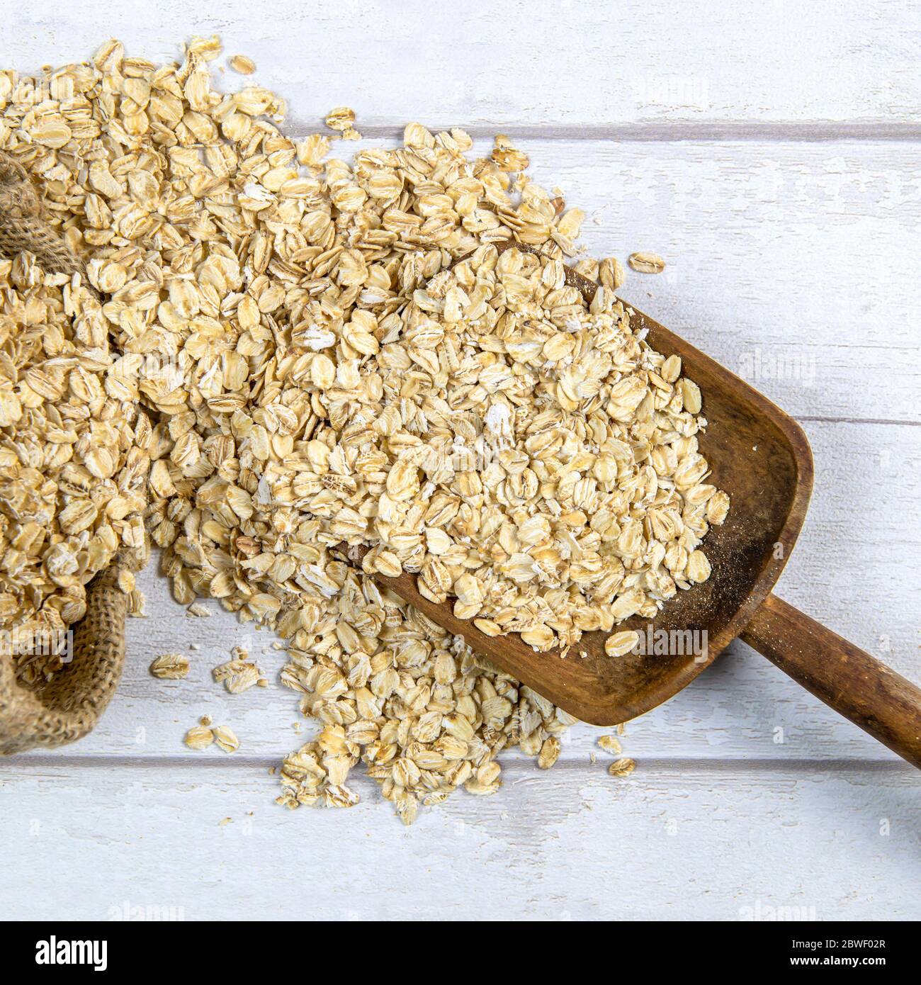 square image of rustic spade and linen sack with uncooked oatmeal ...