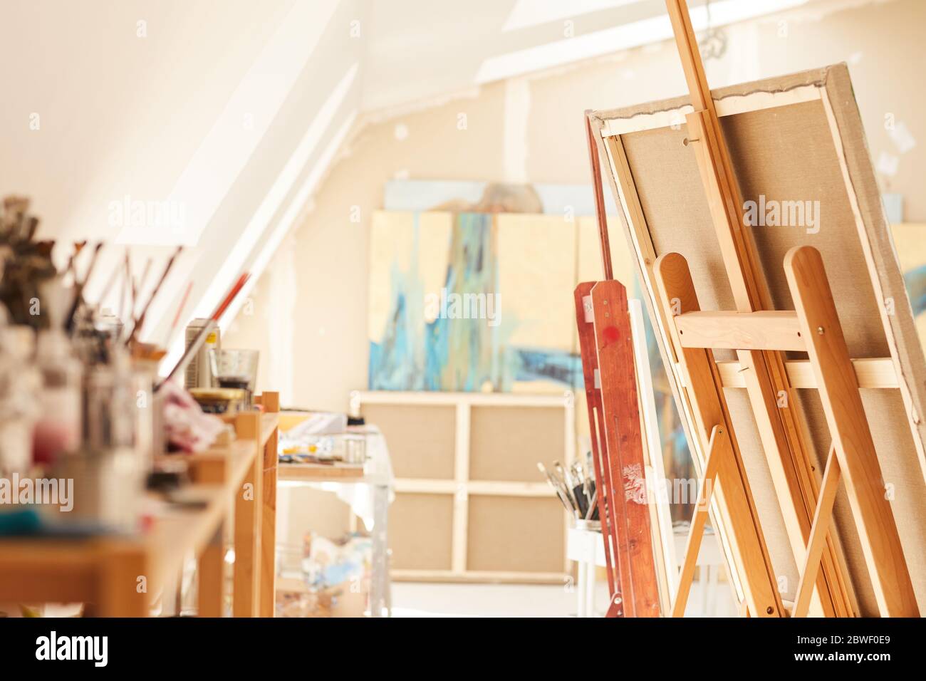 Warm-toned background image of empty art studio interior lit by ...