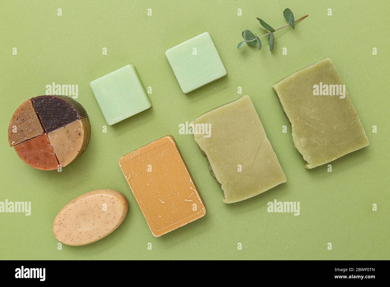 Natural soap of different shapes and a sprig of eucalyptus on a green ...