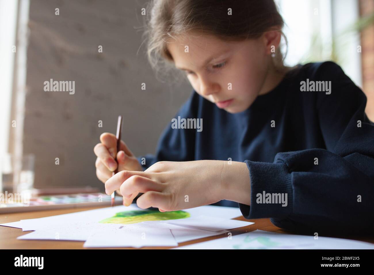 Close up girl drawing with paints and pencils at home, using tutorials ...