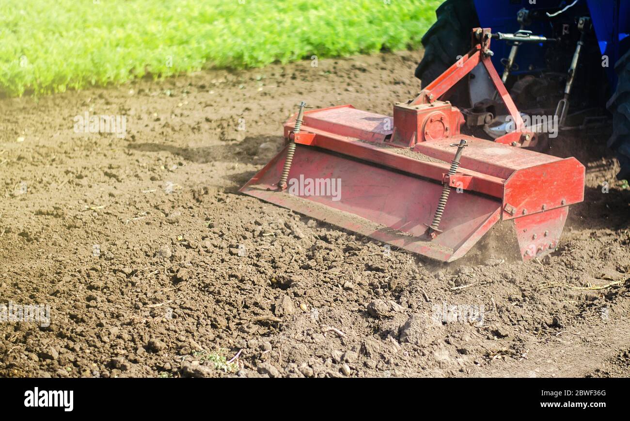 Tractor with milling machine loosens, grinds and mixes ground. Grinding ...