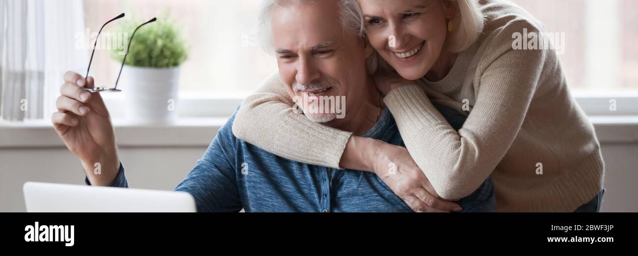 Wife hug husband looking at pc screen read good news Stock Photo - Alamy