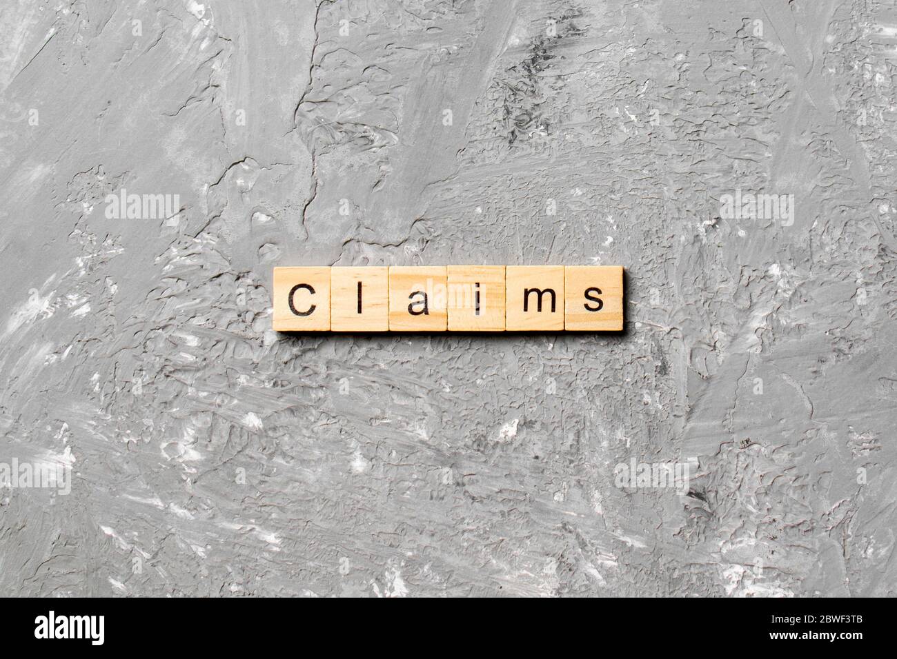 claims word written on wood block. claims text on cement table for your ...