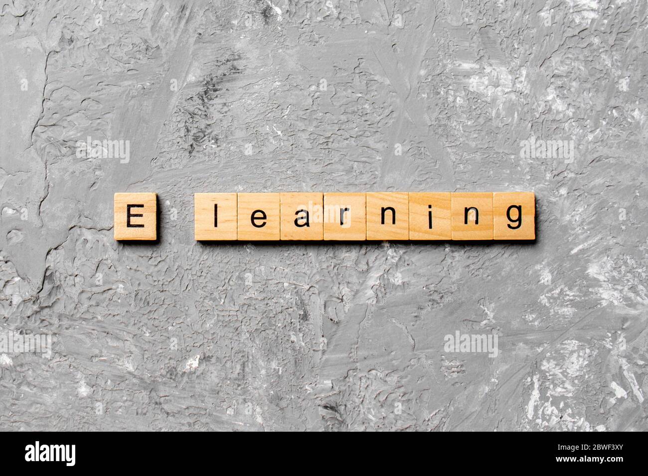 E learning word written on wood block. Elearning text on cement table ...