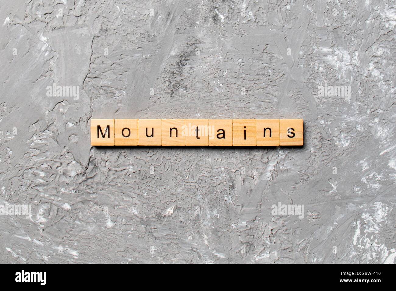 mountains word written on wood block. mountains text on cement table ...
