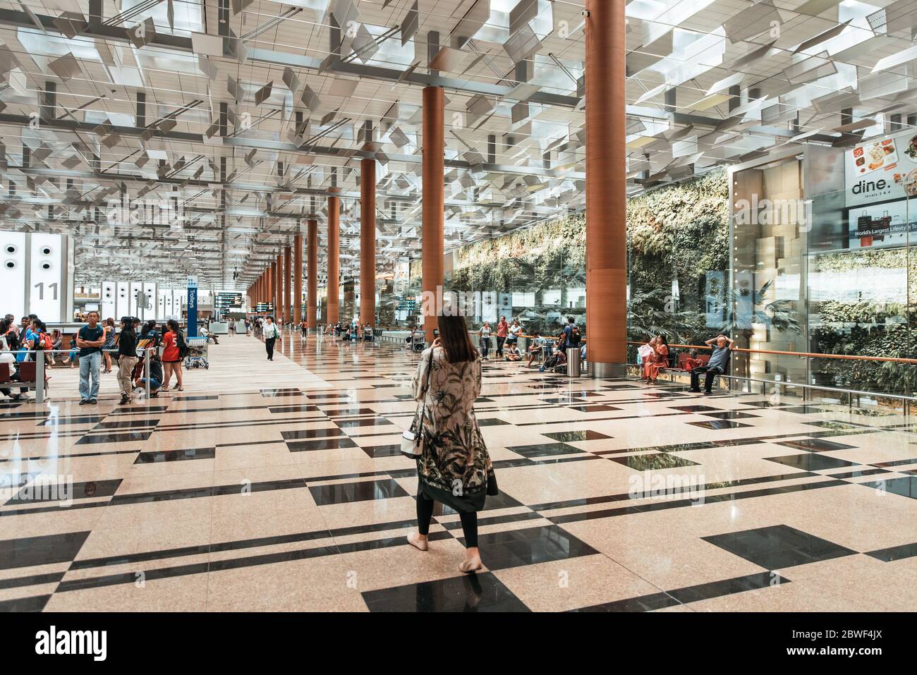 Singapore, Nov 2019: Girl tourist walking inside Departure hall with ...