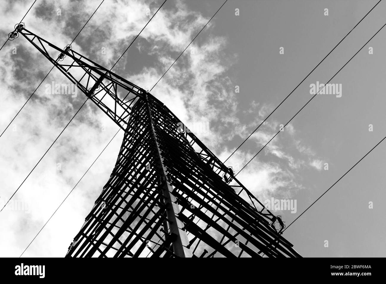Electricity pylon with light cloudy sky in black and white, seen from ...