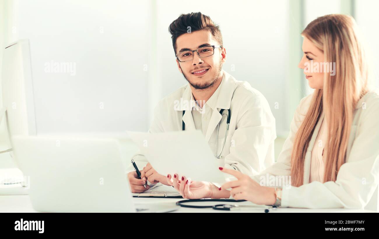 doctors colleagues talking sitting at a table in the office Stock Photo ...