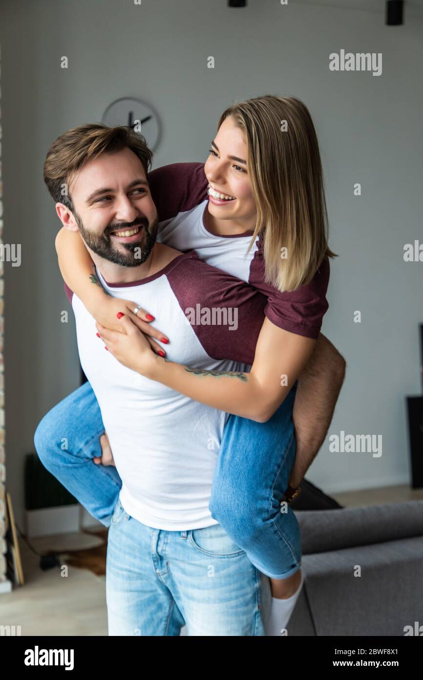 Portrait of funny comic couple, strong man carrying on back cheerful ...