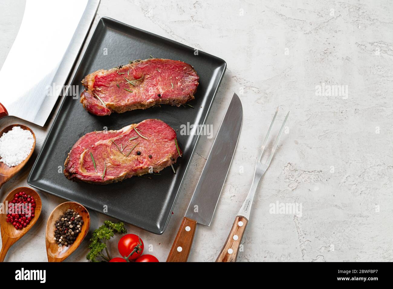 Marinated raw steaks on stone table with spices Stock Photo - Alamy