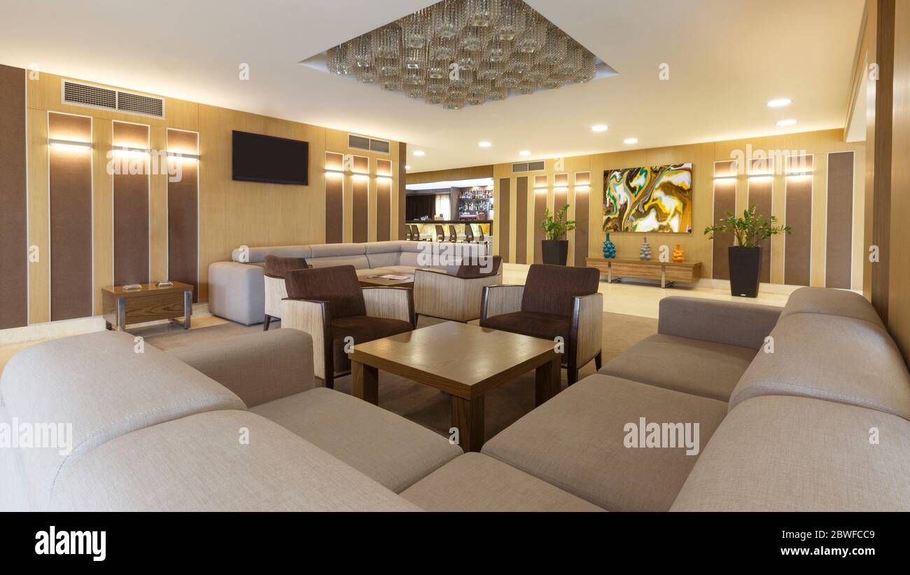 Large sofa, table and plants in hotel lounge Stock Photo - Alamy