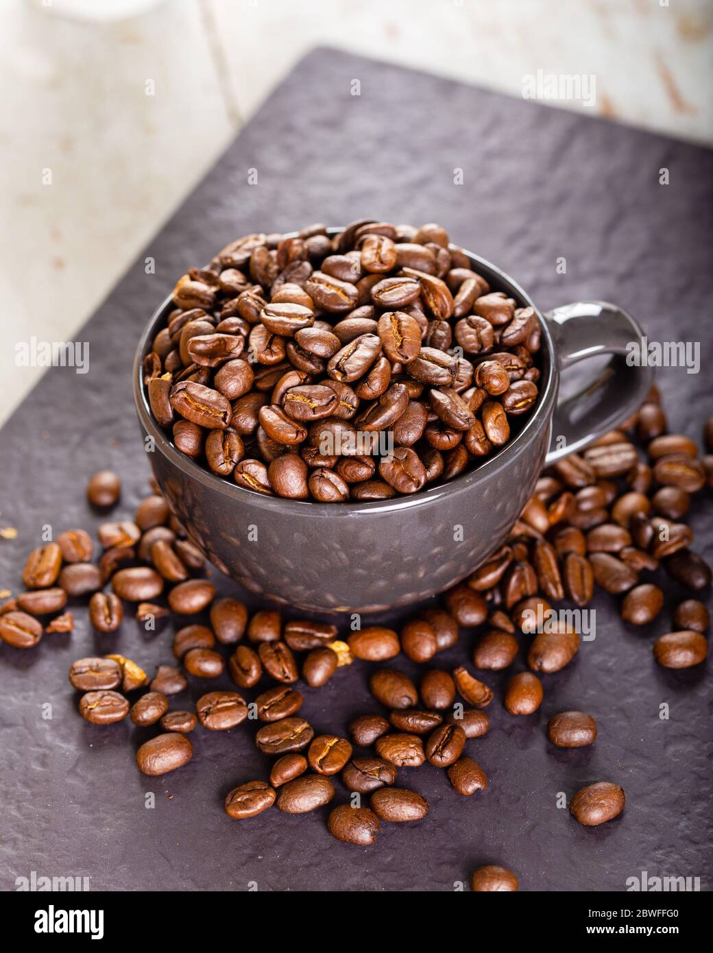 Coffee cup full of coffee beans Stock Photo - Alamy