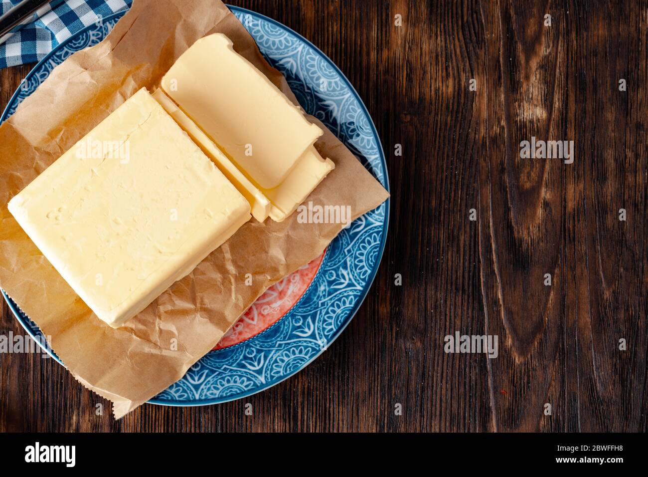 Cut butter on plate with blue towel on kitchen table Stock Photo - Alamy